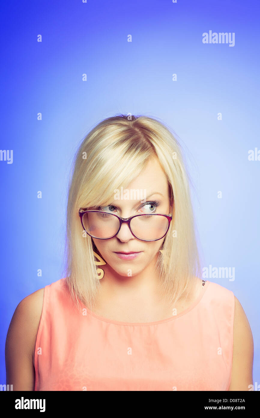 Portrait of a young skeptical woman isolated over blue background Stock ...