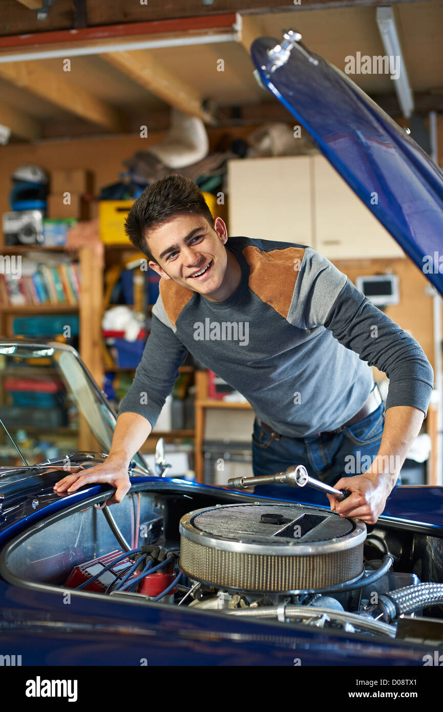 Teenage boy working on sports car in garage Stock Photo - Alamy