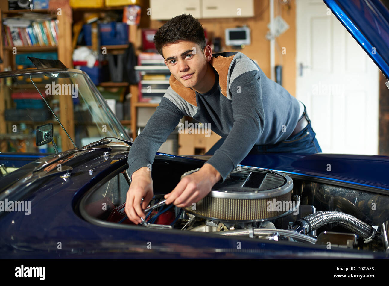 Teenage boy working on sports car in garage Stock Photo - Alamy
