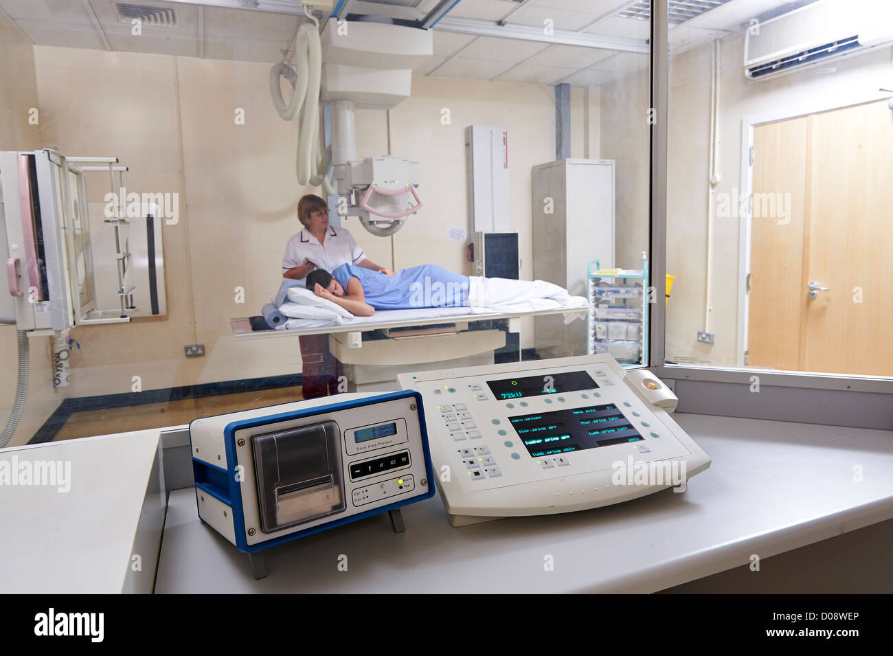 teenage boy patient in X Ray department with nurse and radiographer preparing him for an X Ray ...