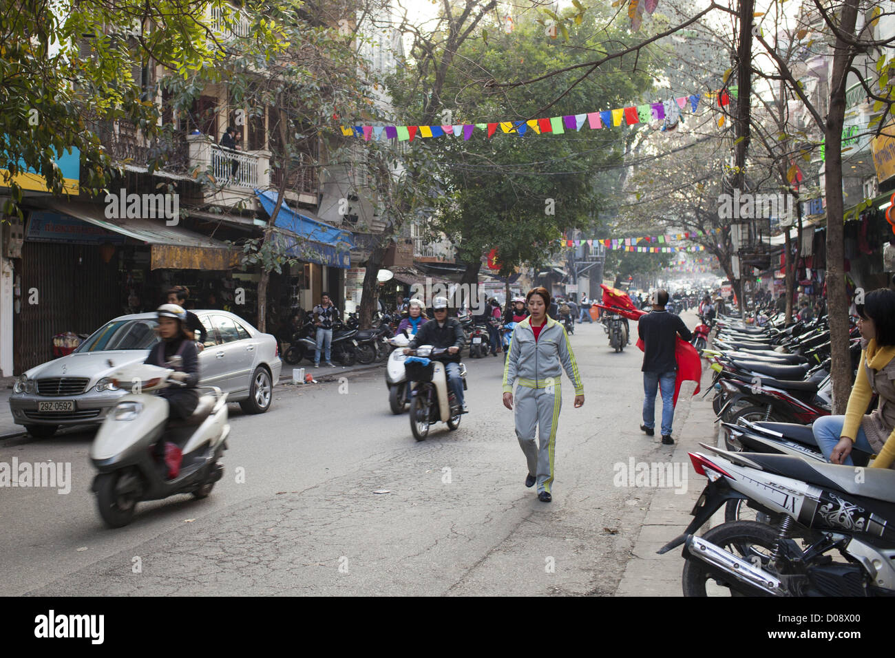 TRAFFIC AND PEDESTRIANS ON A STREET IN THE OLD QUARTER OF HANOI VIETNAM ...