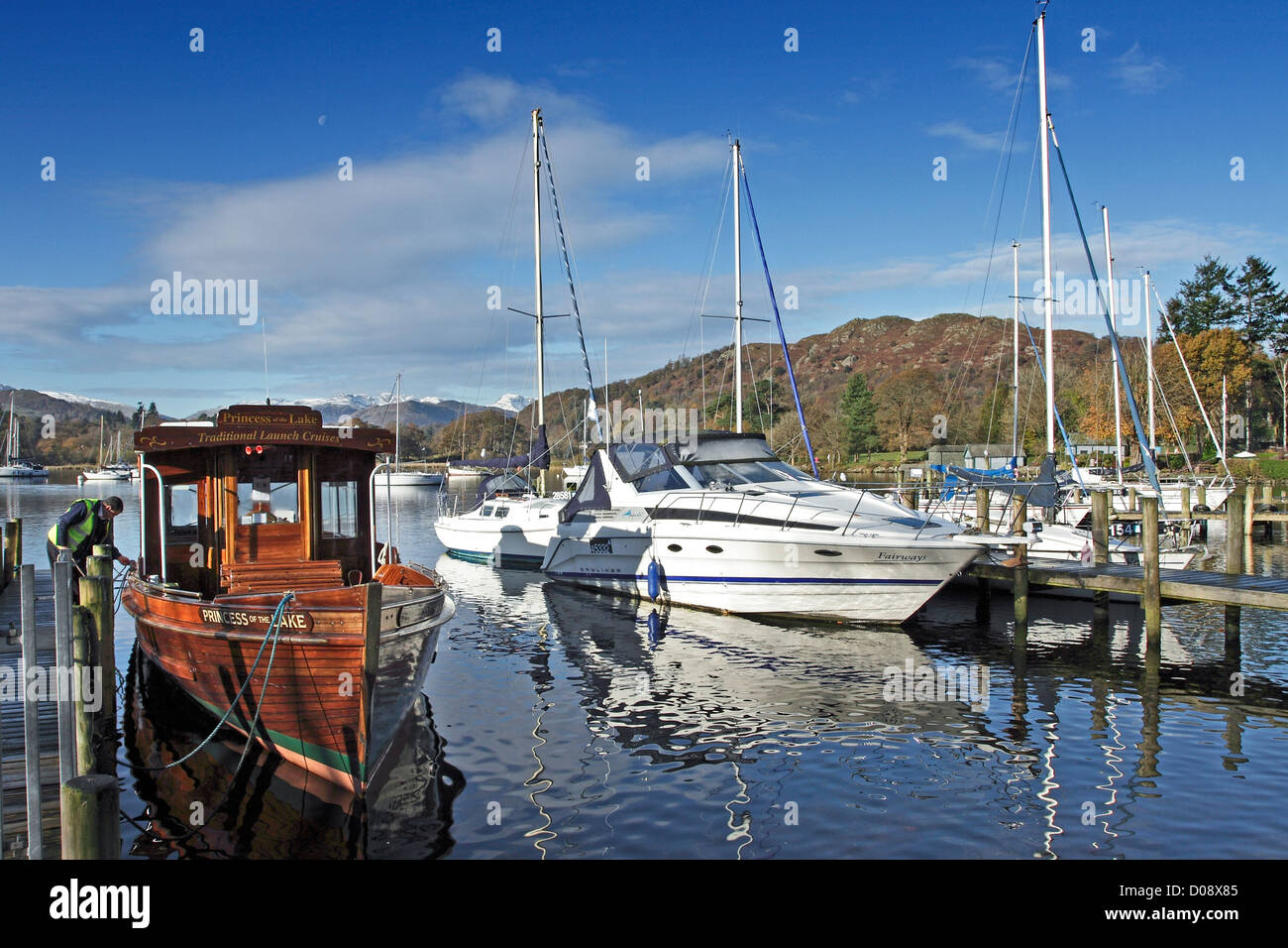 Modern power boats and yachts and a traditional wooden launch moored at ...