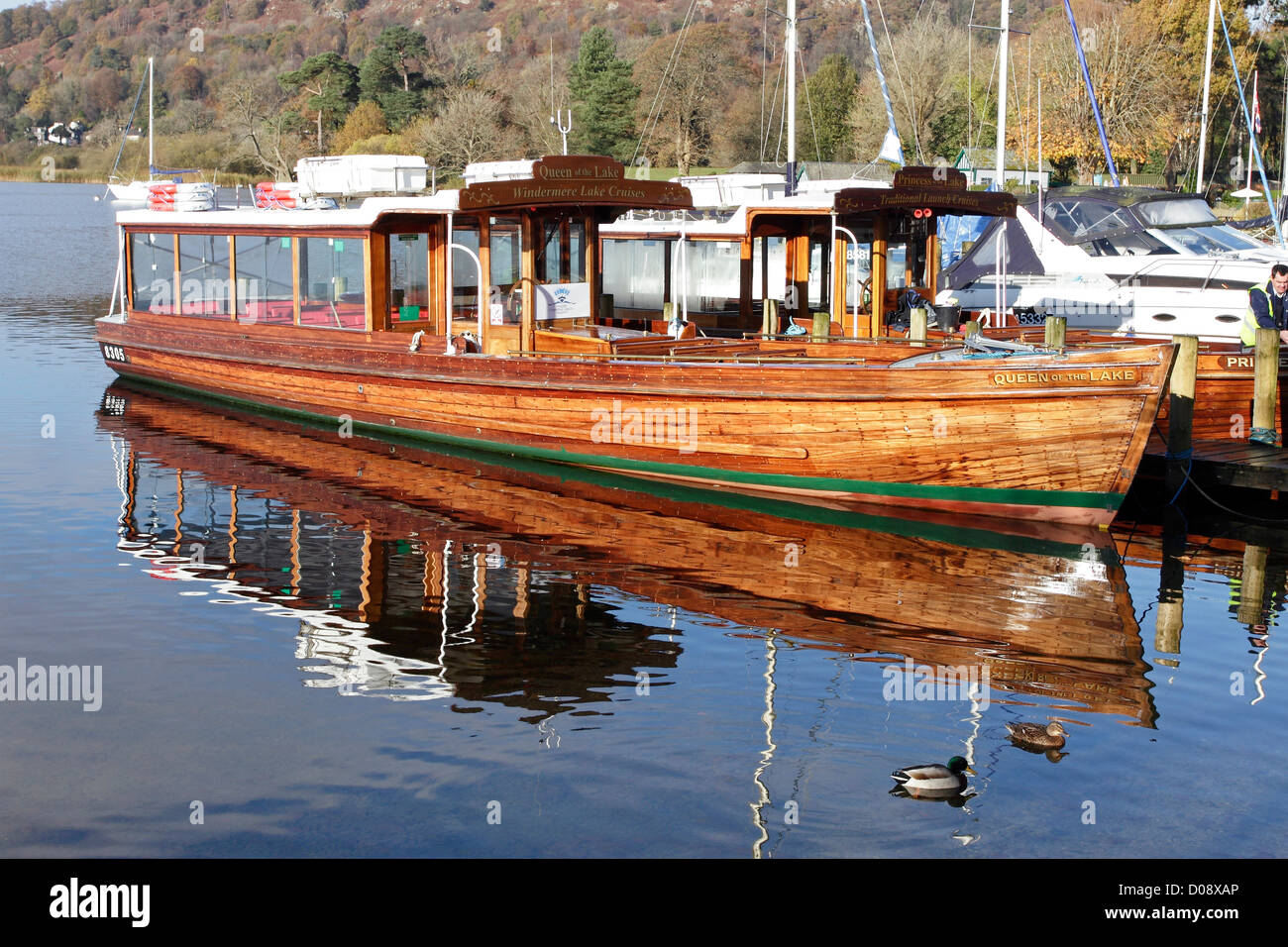 A traditional wooden launch moored at a jetty in Waterhead, Ambleside ...