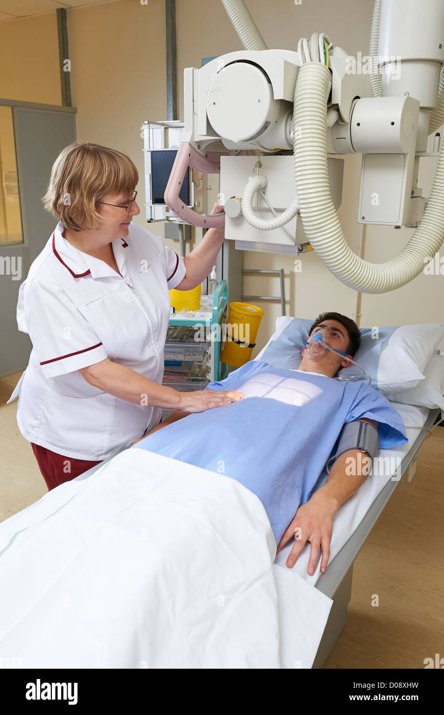 radiographer taking X ray of teenage patient in hospital X ray ...