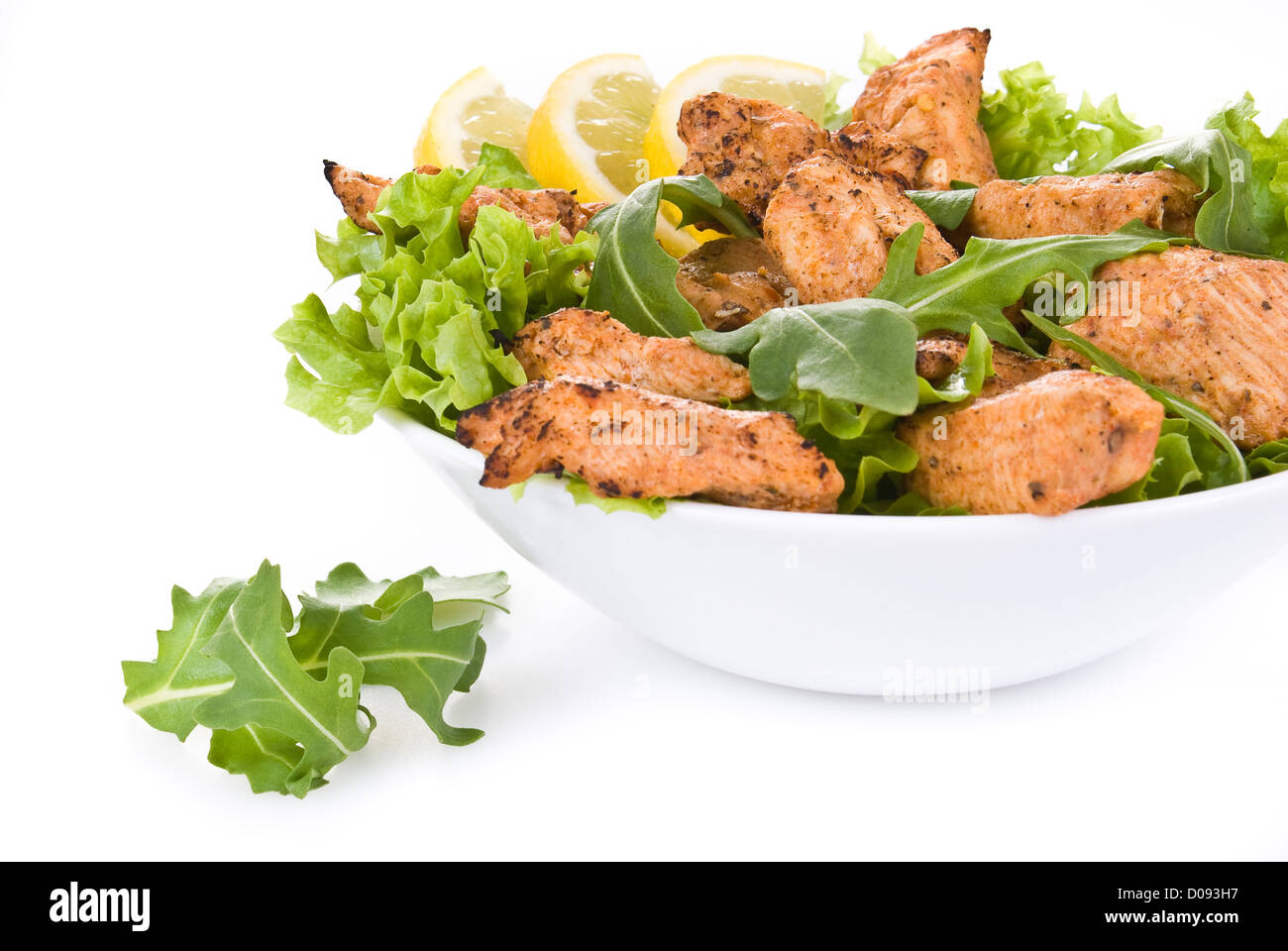 Chicken salad with dropped leaves over white background Stock Photo - Alamy