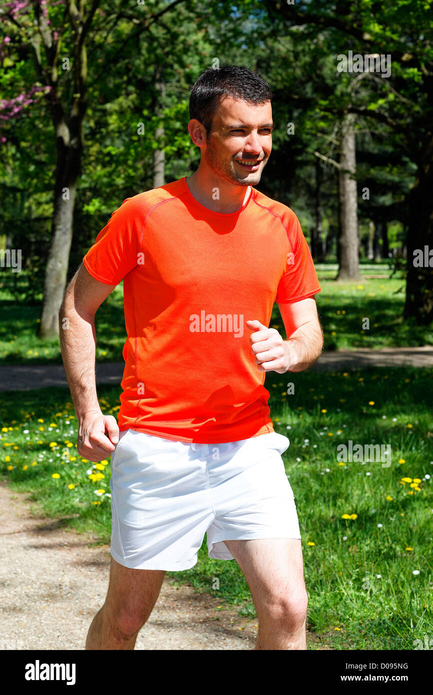 young man running in a park in spring Stock Photo - Alamy