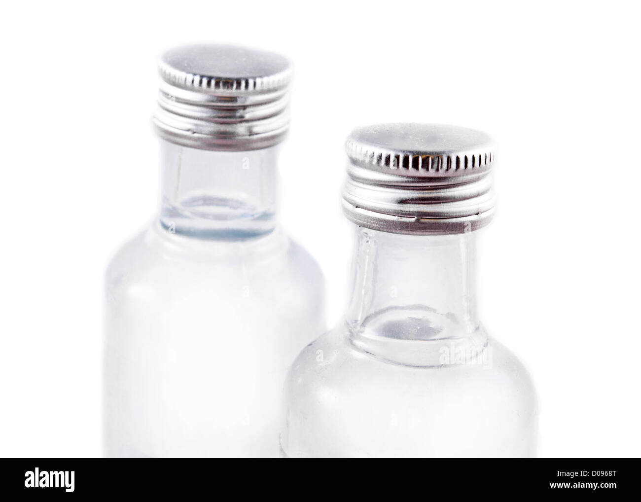 Two bottles filled with liquor on white background Stock Photo - Alamy