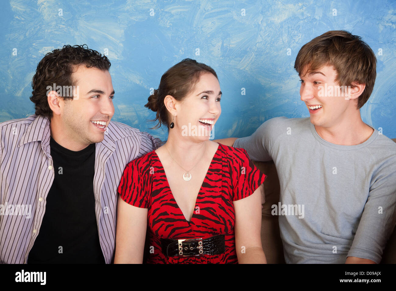 Group of three happy friends over blue background Stock Photo - Alamy