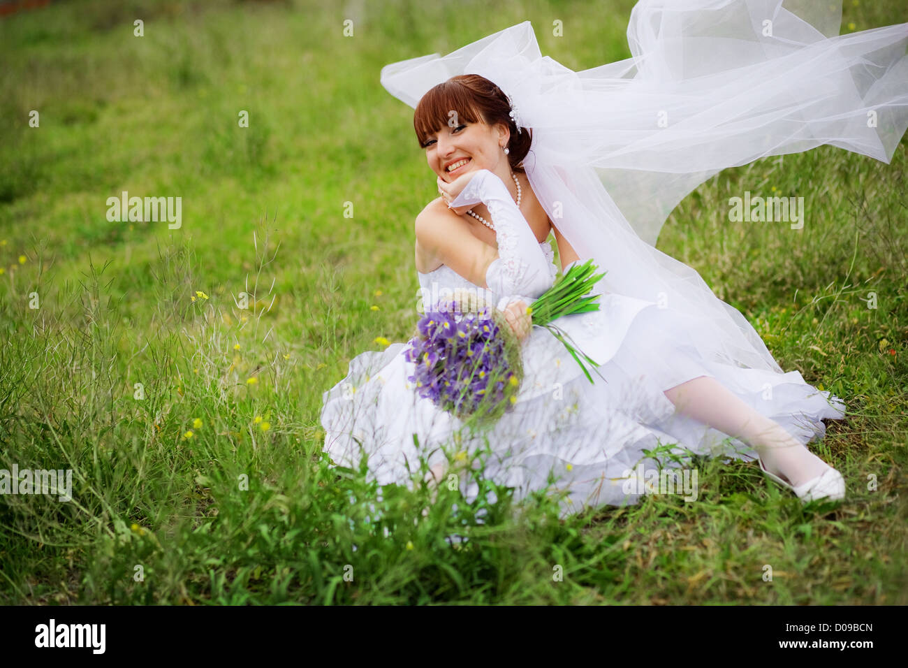 Happy bride posing on grass in spring Stock Photo - Alamy