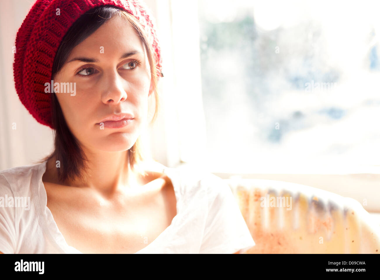 Young woman looking out of sunny window Stock Photo - Alamy