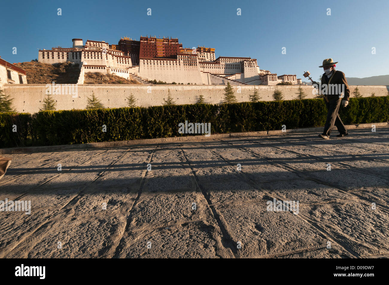 Tibetan Buddhist pilgrim carrying prayer wheel walks around Portala ...