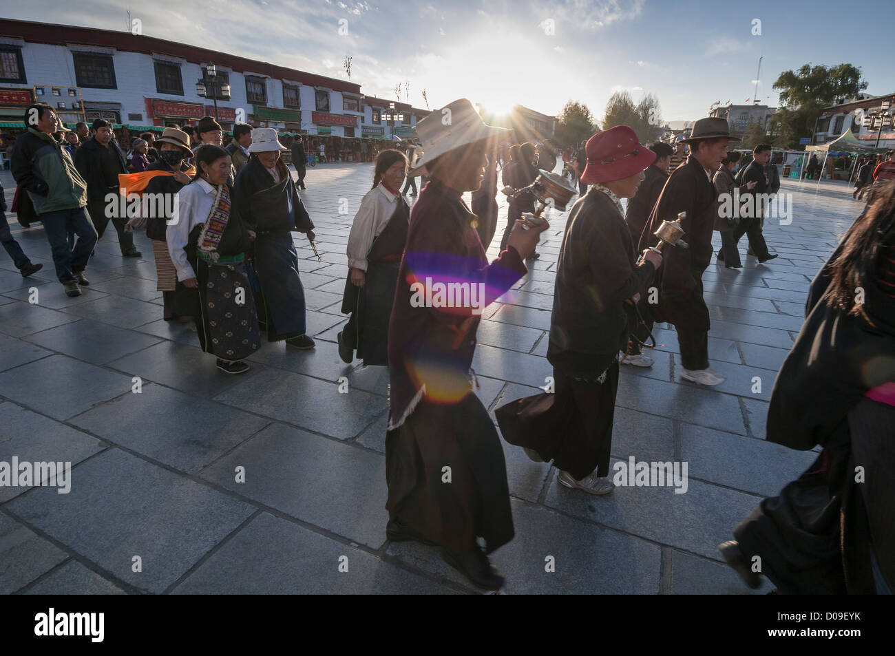 Buddhist pilgrims circle the Jokhang Temple at sunset, Barkhor Square ...