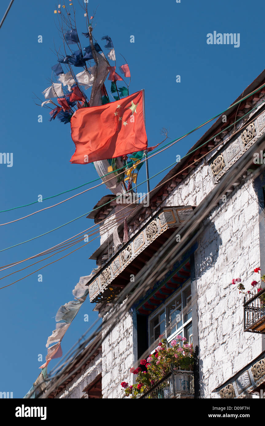 Chinese flag shares rooftop with traditional Buddhist prayer flags near ...
