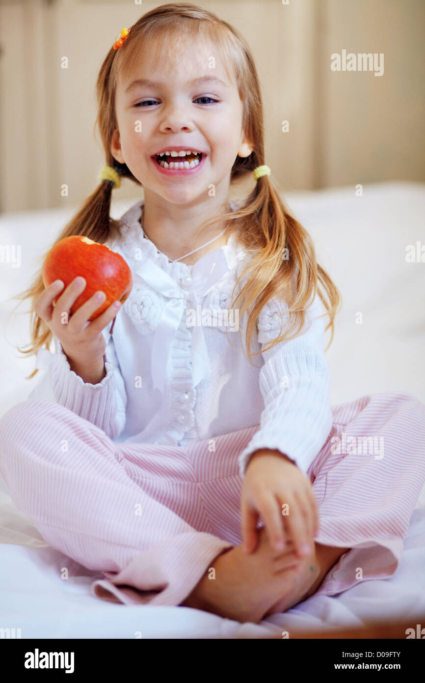 Casual of cute child with apple in bed Stock Photo - Alamy