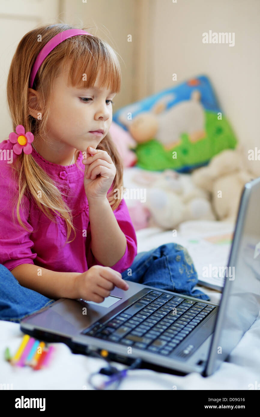 Little cute child playing with laptop at home Stock Photo - Alamy