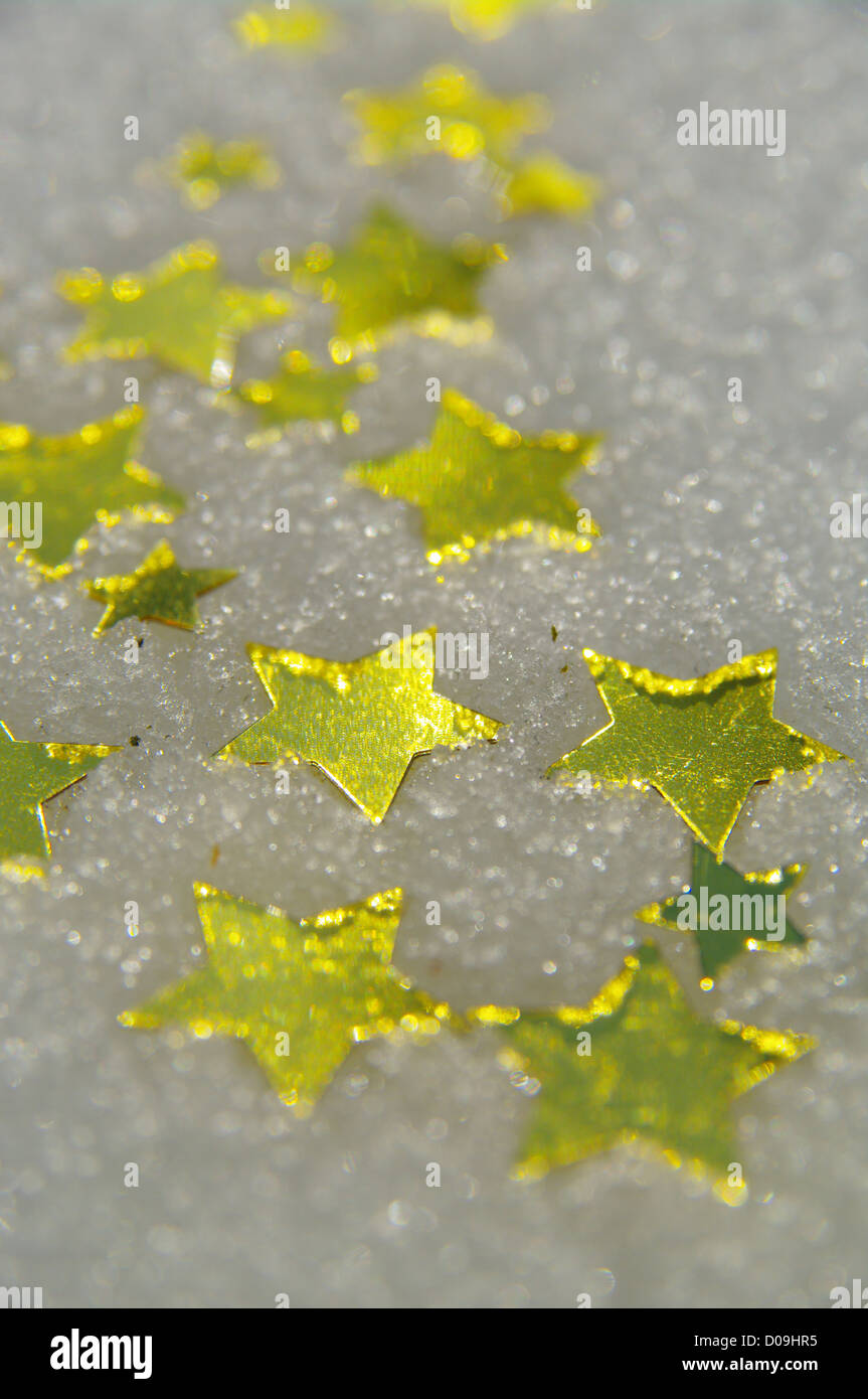 golden snow stars on a real snowy icy surface Stock Photo - Alamy