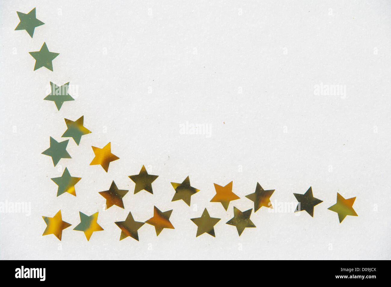 golden snow stars on a real snowy icy surface Stock Photo - Alamy