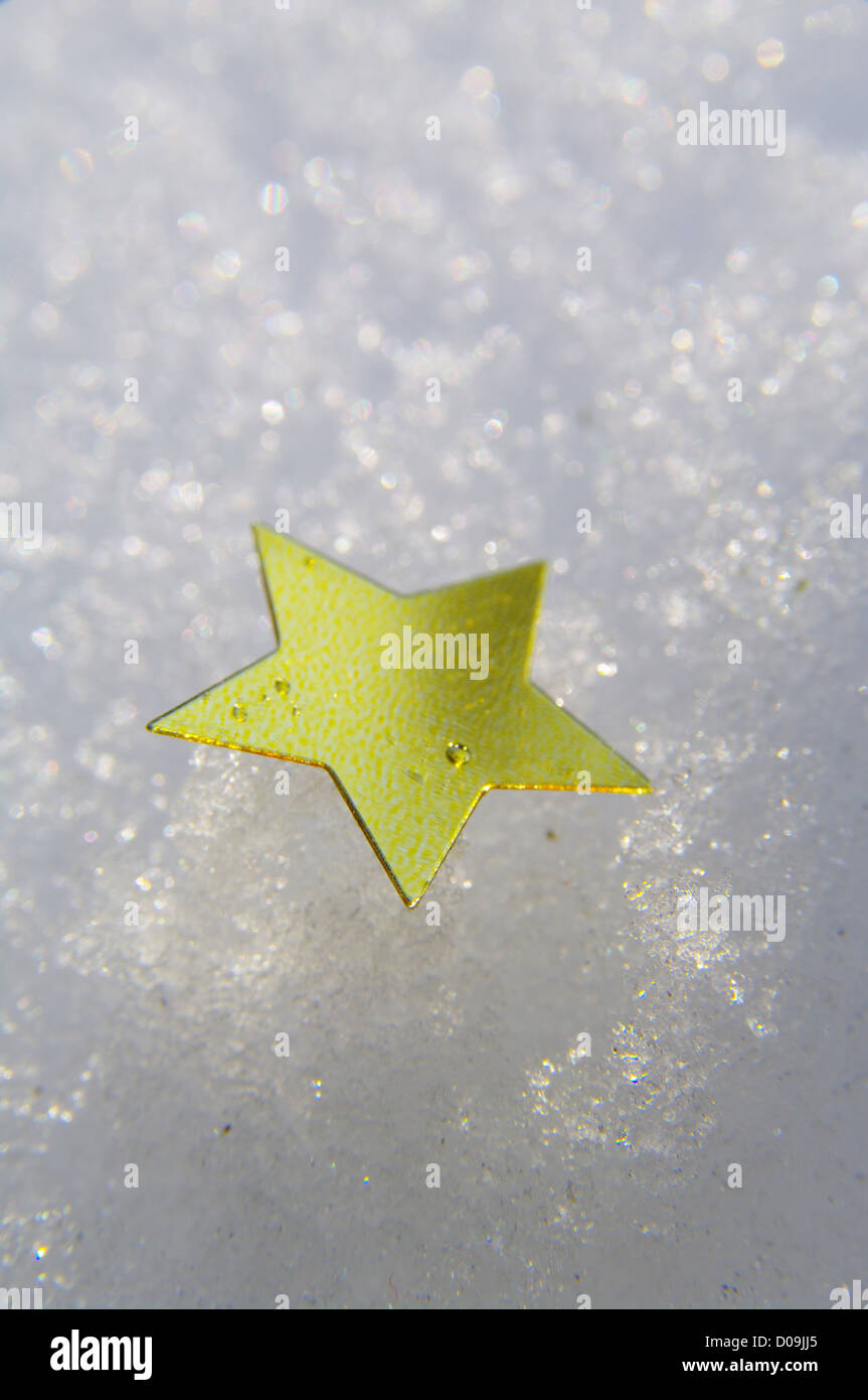 golden snow stars on a real snowy icy surface Stock Photo - Alamy