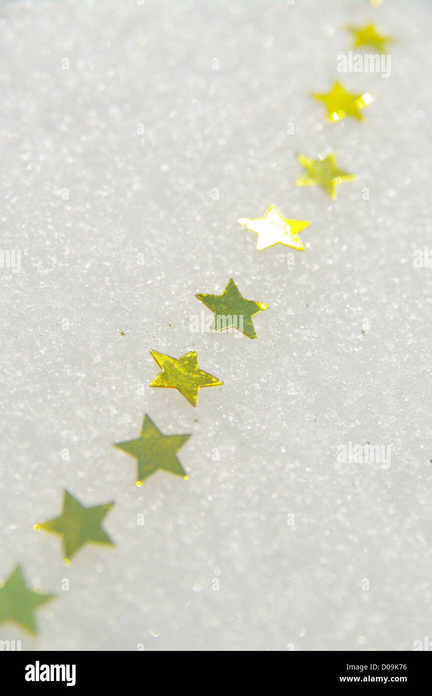 golden snow stars on a real snowy icy surface Stock Photo - Alamy