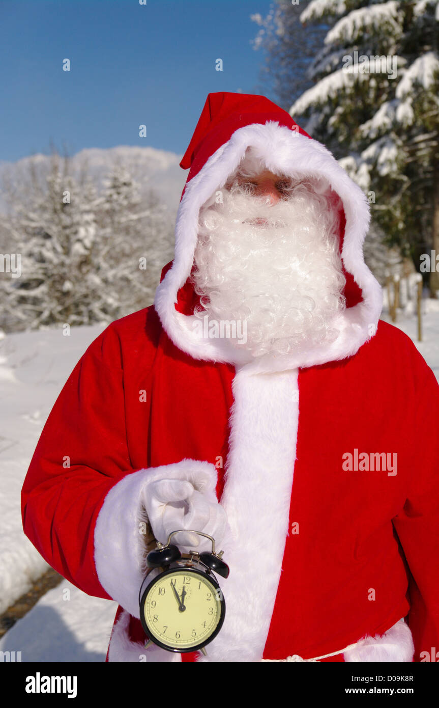 Santa Claus, Father Christmas holds watch clock Stock Photo - Alamy
