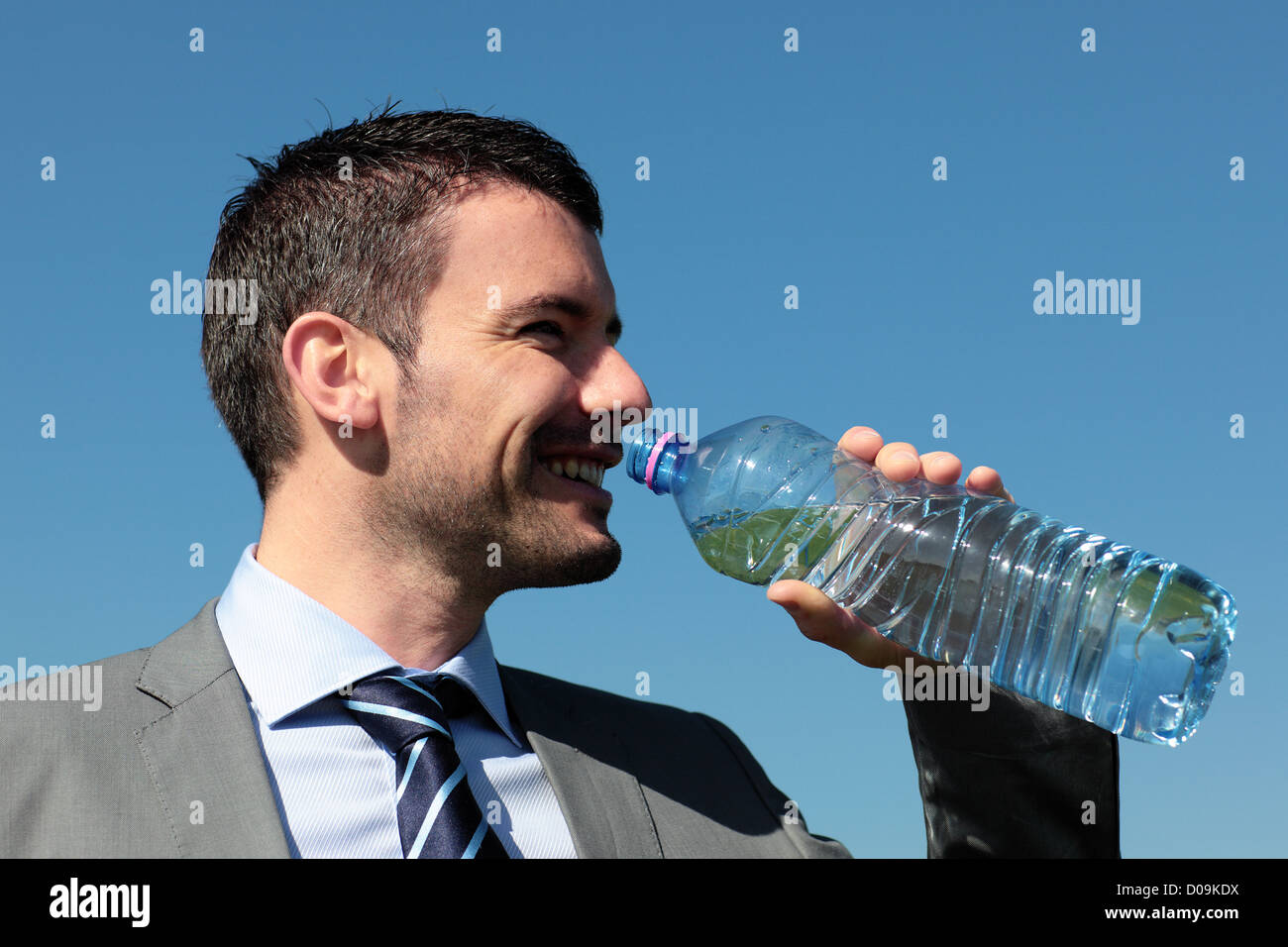 handsome businessman drinking water with bottle in blue sky Stock Photo ...