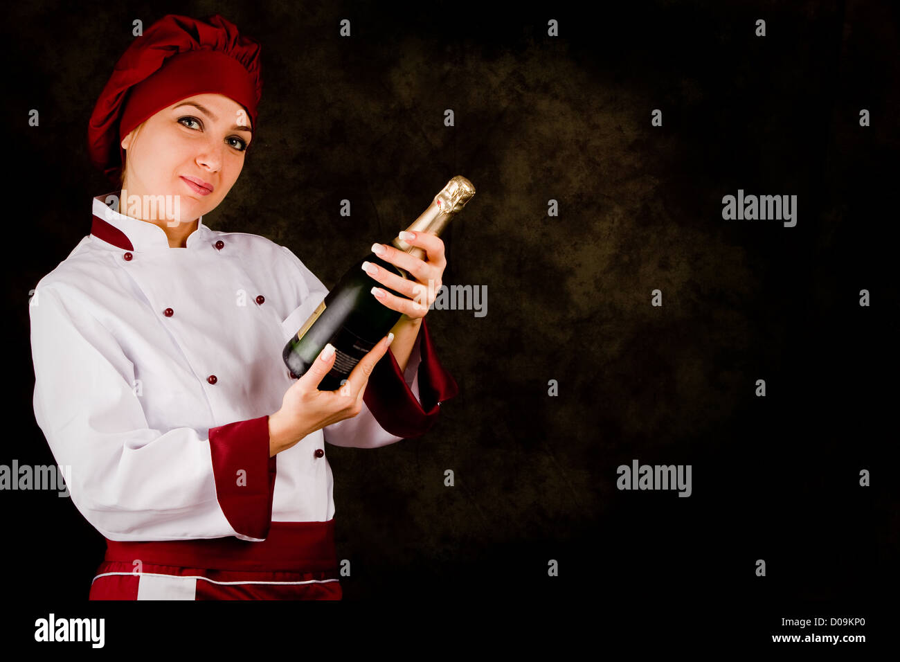 photo of young female chef with champagne bottle ready to open it Stock ...