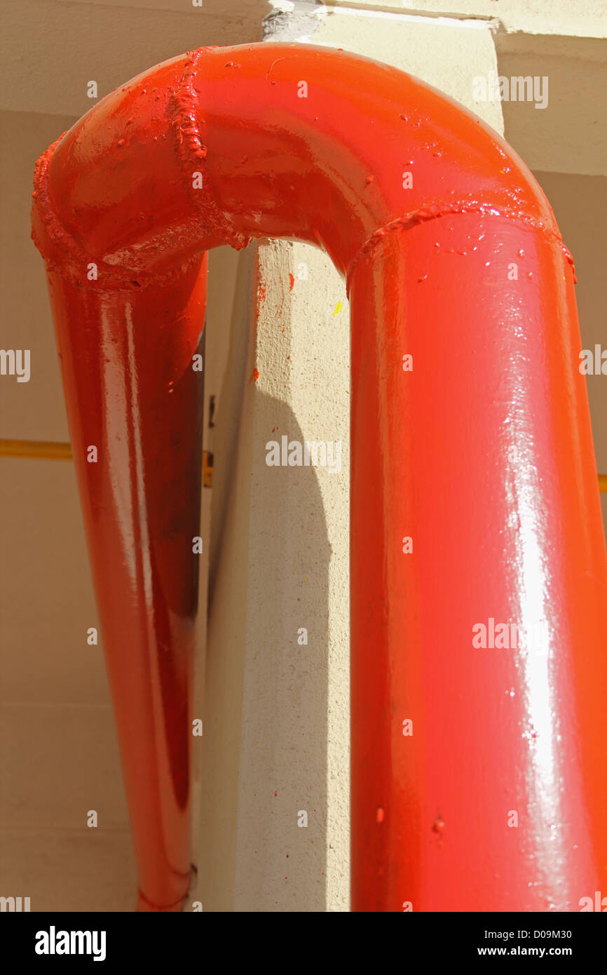 Red fire water lines in front of a building Stock Photo - Alamy