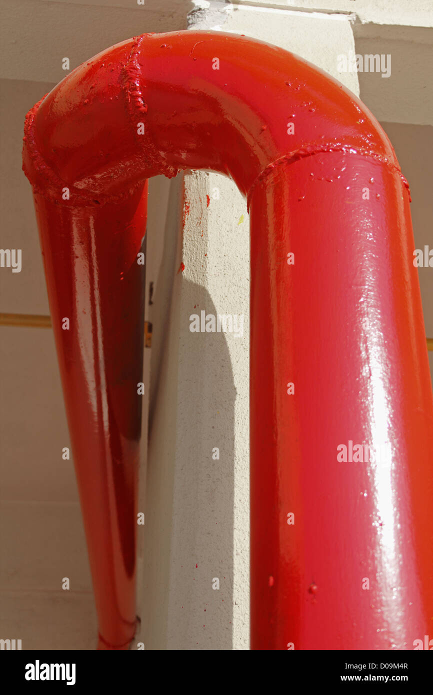Red fire water lines in front of a building Stock Photo - Alamy