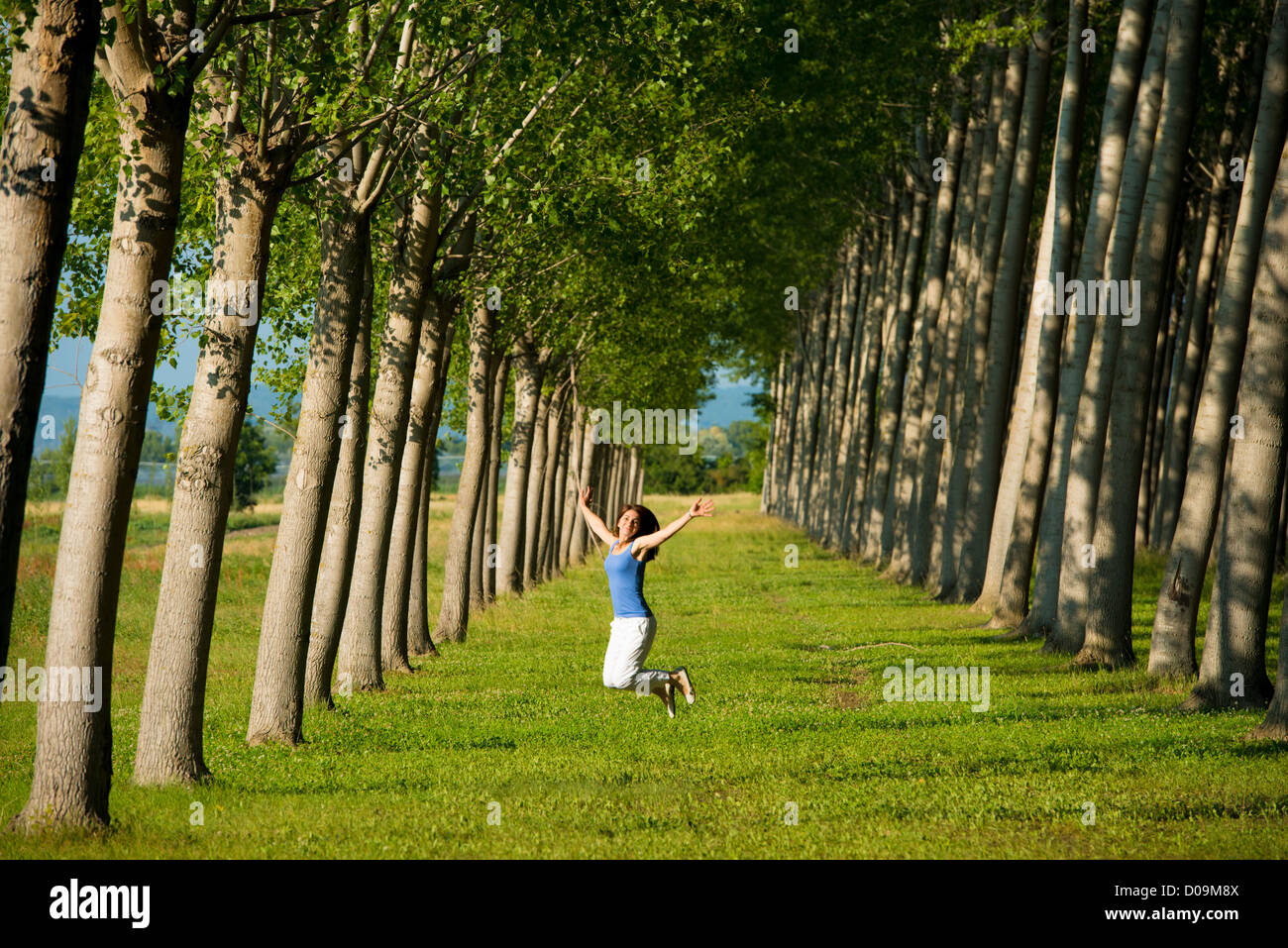 happy woman jumping outdoors in a forest Stock Photo - Alamy