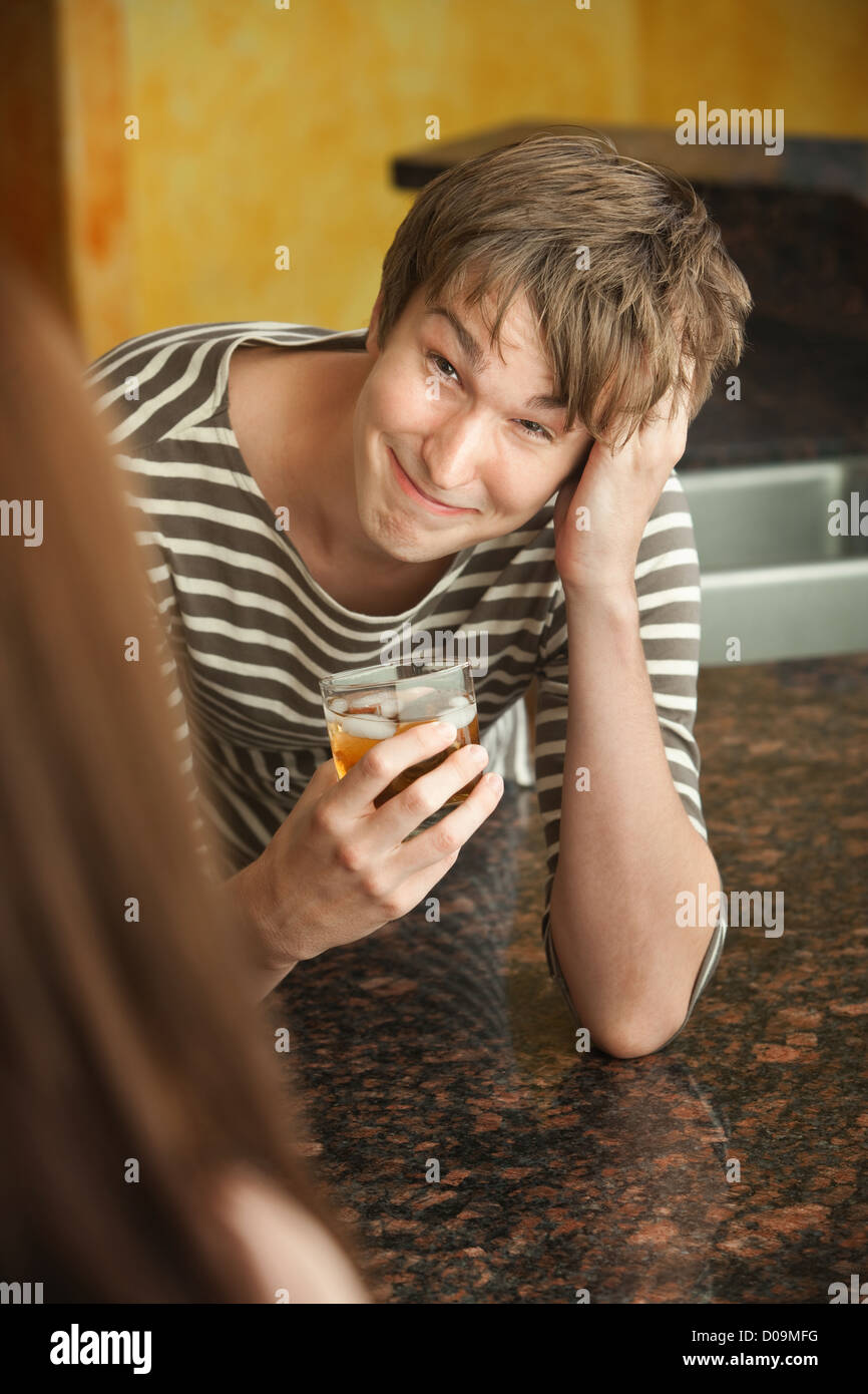 Young Man with cold drink in a glass makes a face Stock Photo - Alamy