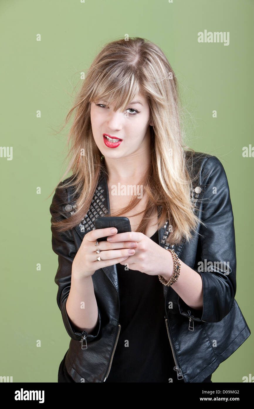 Retro-styled young Caucasian lady types text message on her cellphone ...