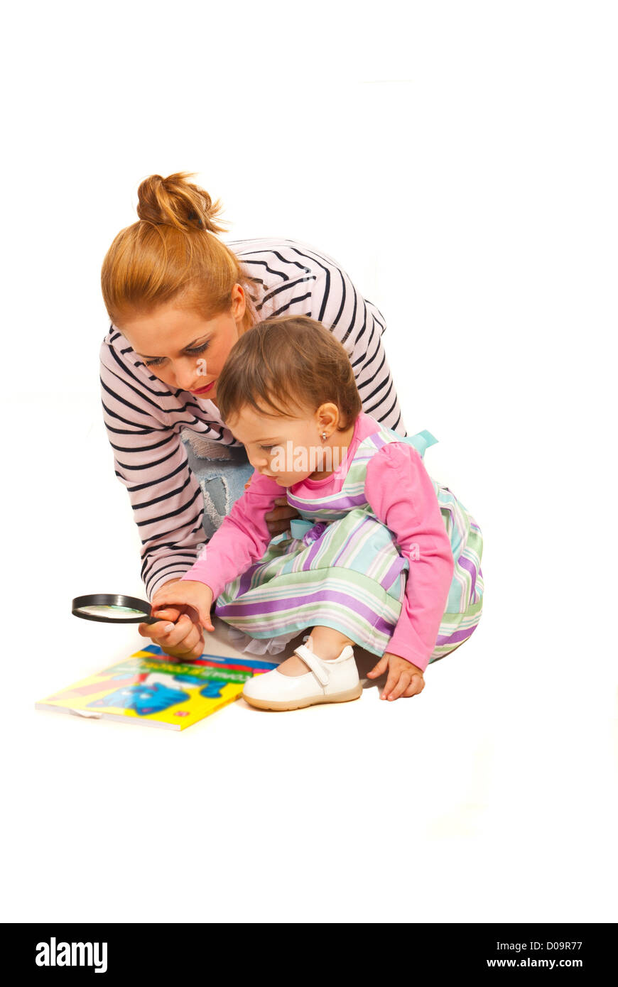 Mother teaching her daughter to read and holding magnifier isolated on ...