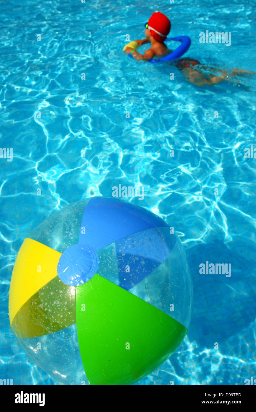 A colorful beach ball floating on the swimming pool Stock Photo - Alamy