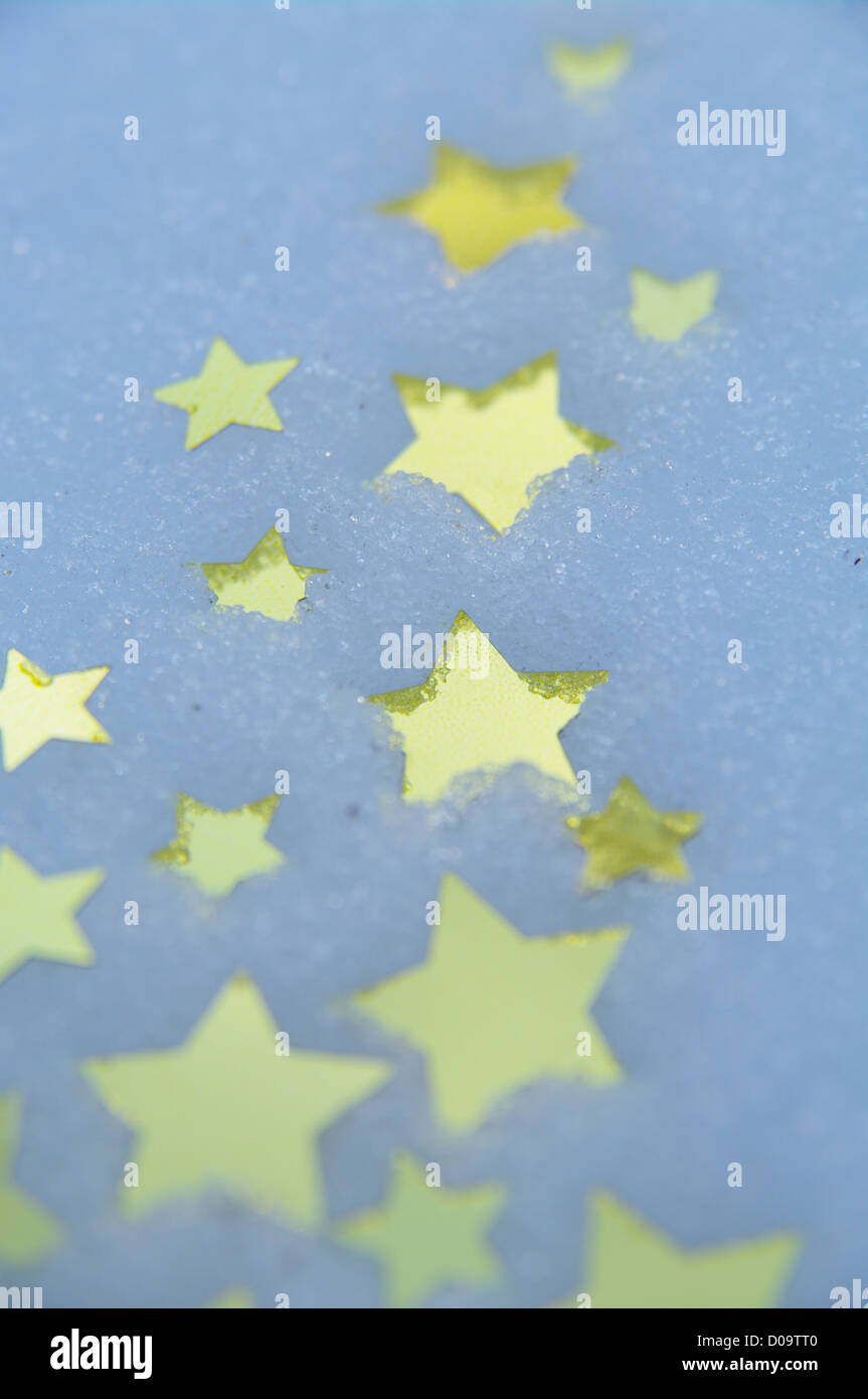golden snow stars on a real snowy icy surface Stock Photo - Alamy