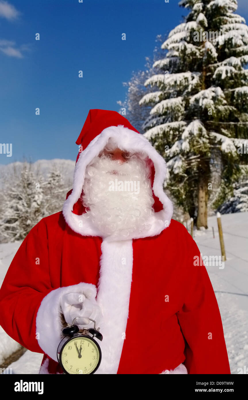 Santa Claus, Father Christmas holds watch clock Stock Photo - Alamy