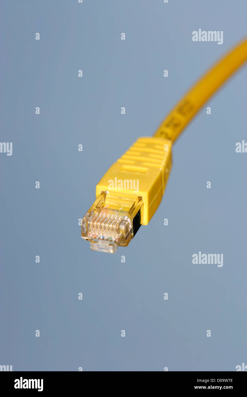 Yellow network cable against blue sky background Stock Photo - Alamy