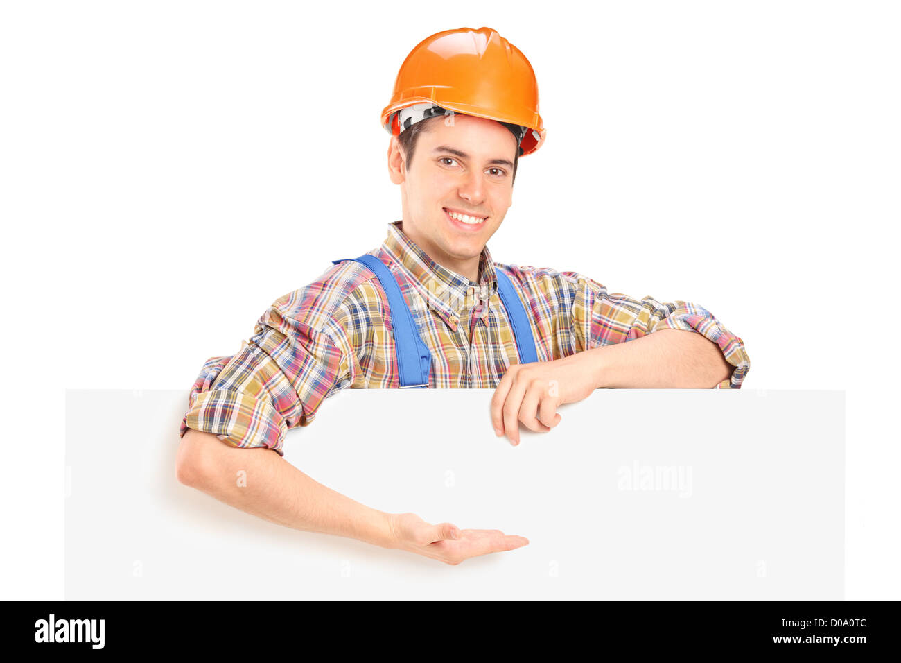 Young construction worker with helmet posing behind a panel and ...