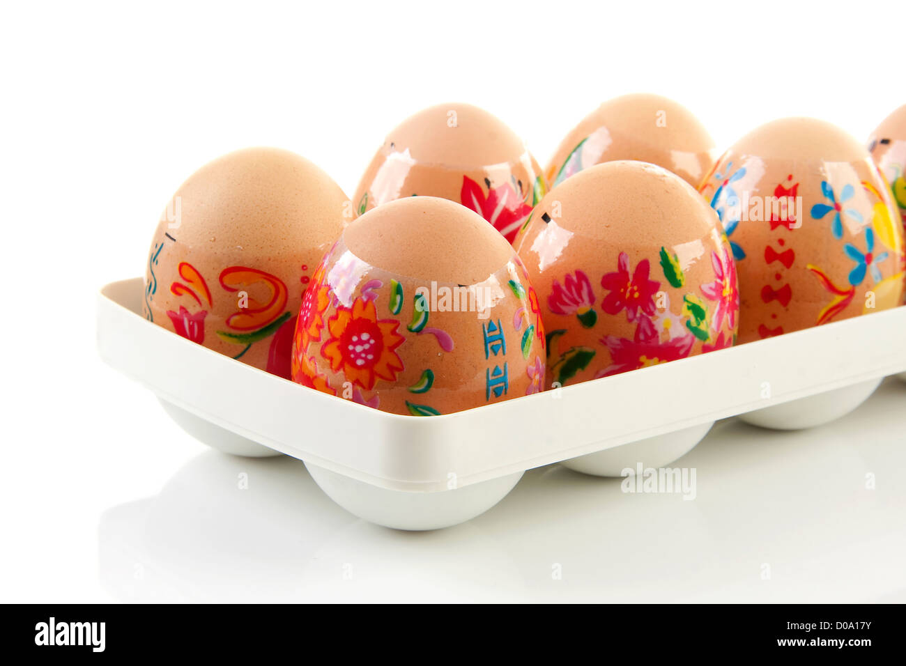 Decorated chicken eggs in holder made by children over white background ...