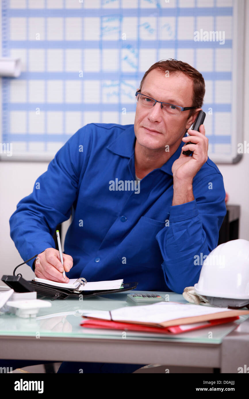 Factory worker ordering more stock Stock Photo - Alamy