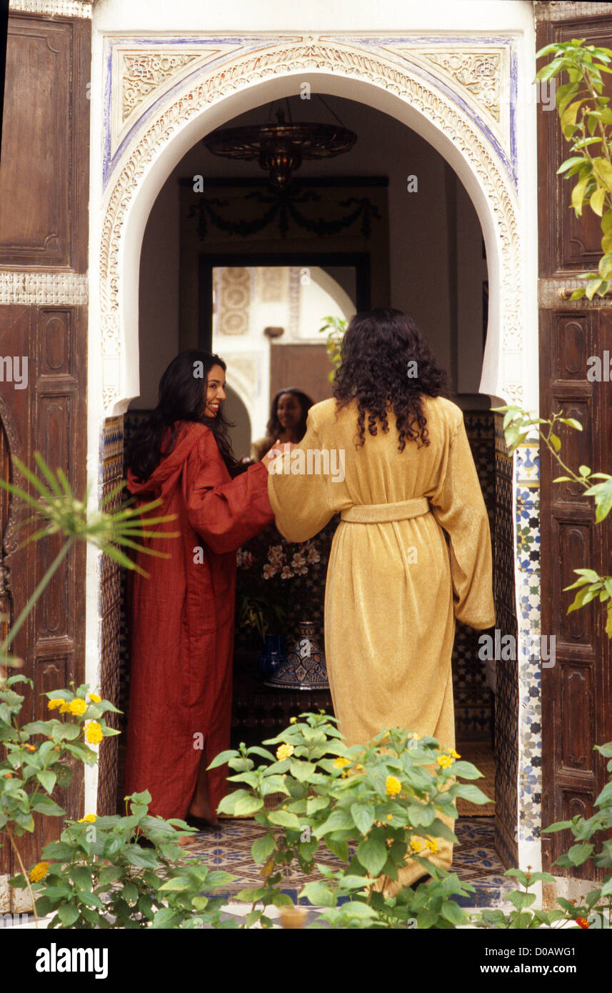 MAGHREB WOMEN WEARING CAFTANS AND DJELLABAS IN THE COURTYARD OF A RIAD ...
