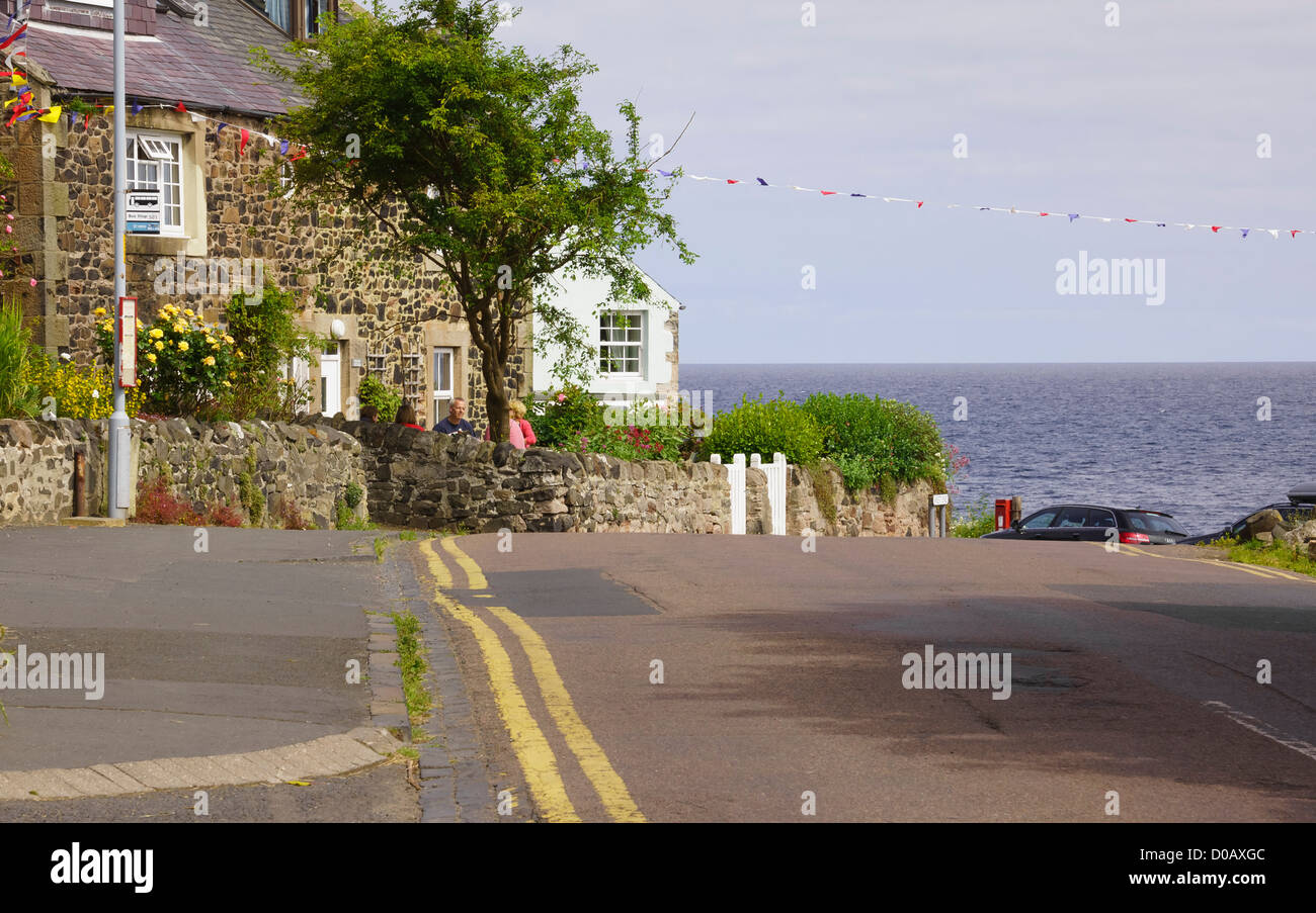 A quiet street leading into the coastal town of Craster in ...