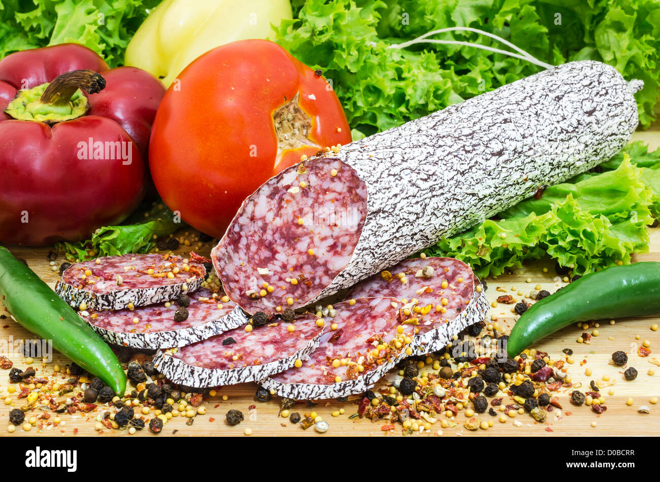 Still life with sliced romanian salami and vegetables Stock Photo - Alamy