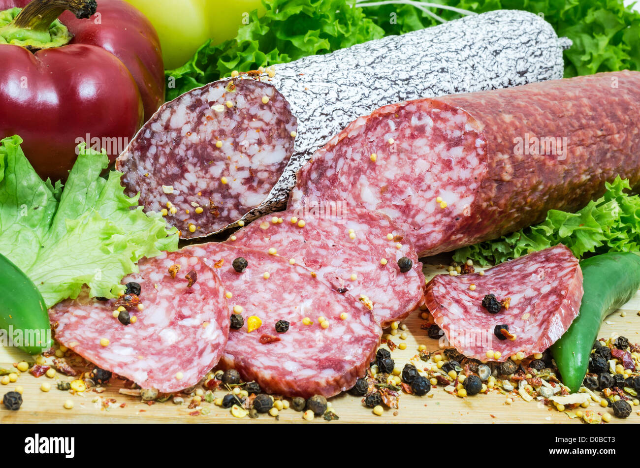 Still life with sliced romanian salami and vegetables Stock Photo - Alamy