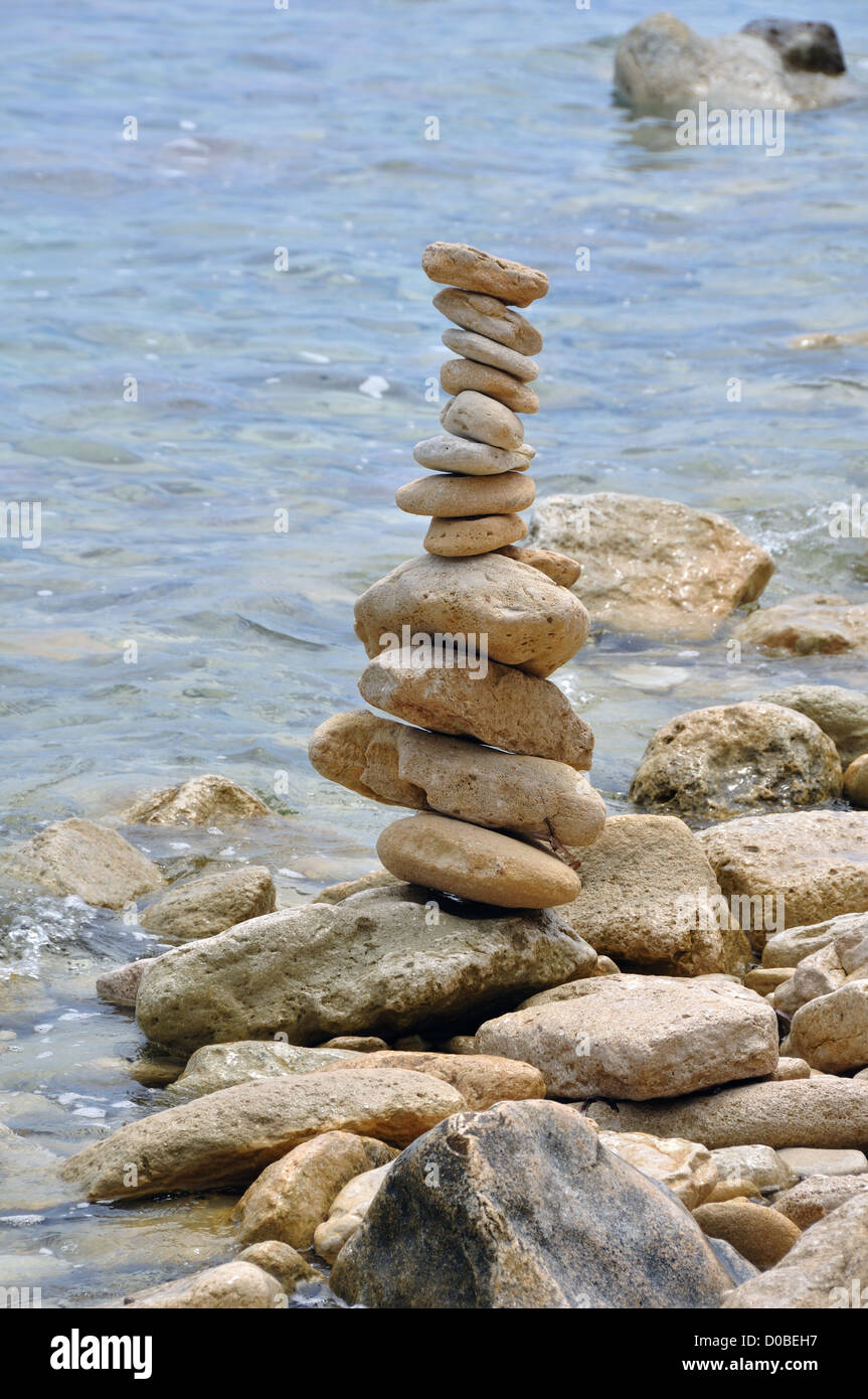 Primitive stone structure on rocky shore. Balanced rocks by the sea ...