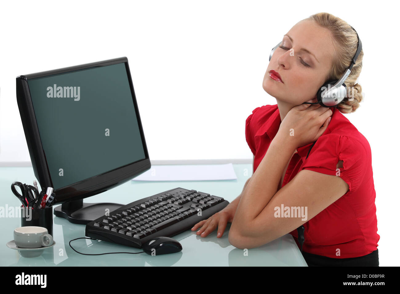 Blond office worker listening to music at desk Stock Photo - Alamy