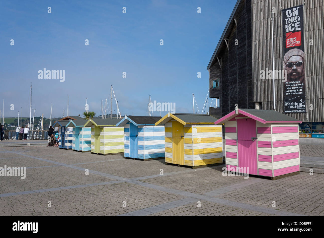 vibrant beach huts on display with poster in background Stock Photo - Alamy