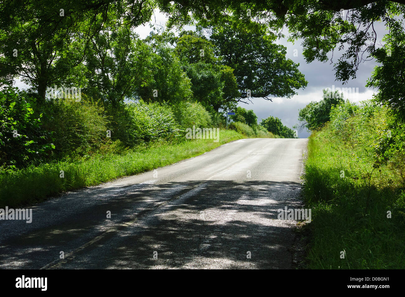 A country lane leading up to the brow of a hill, blind summit, through ...