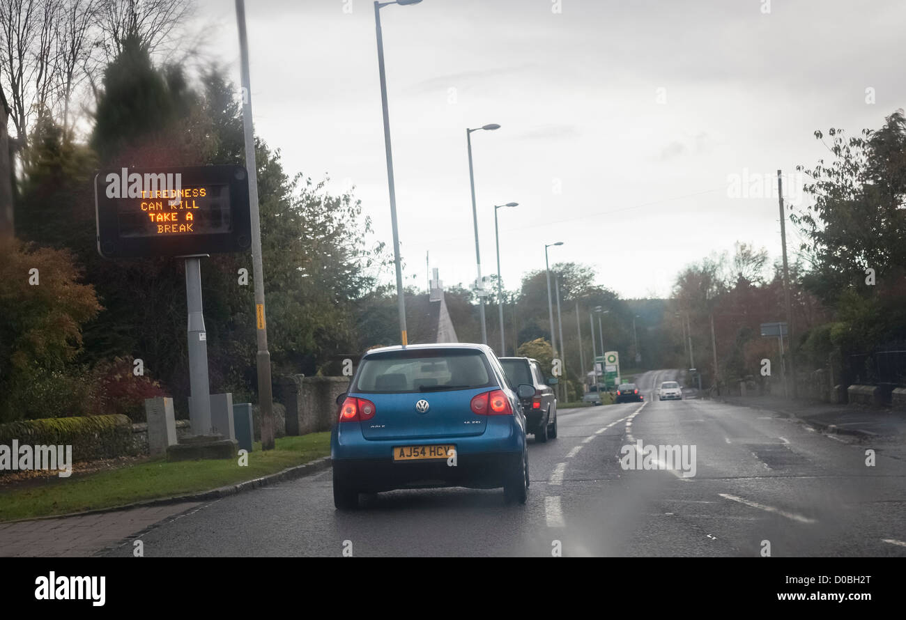 A sign warning of a tiredness while driving on a wet road Stock Photo ...