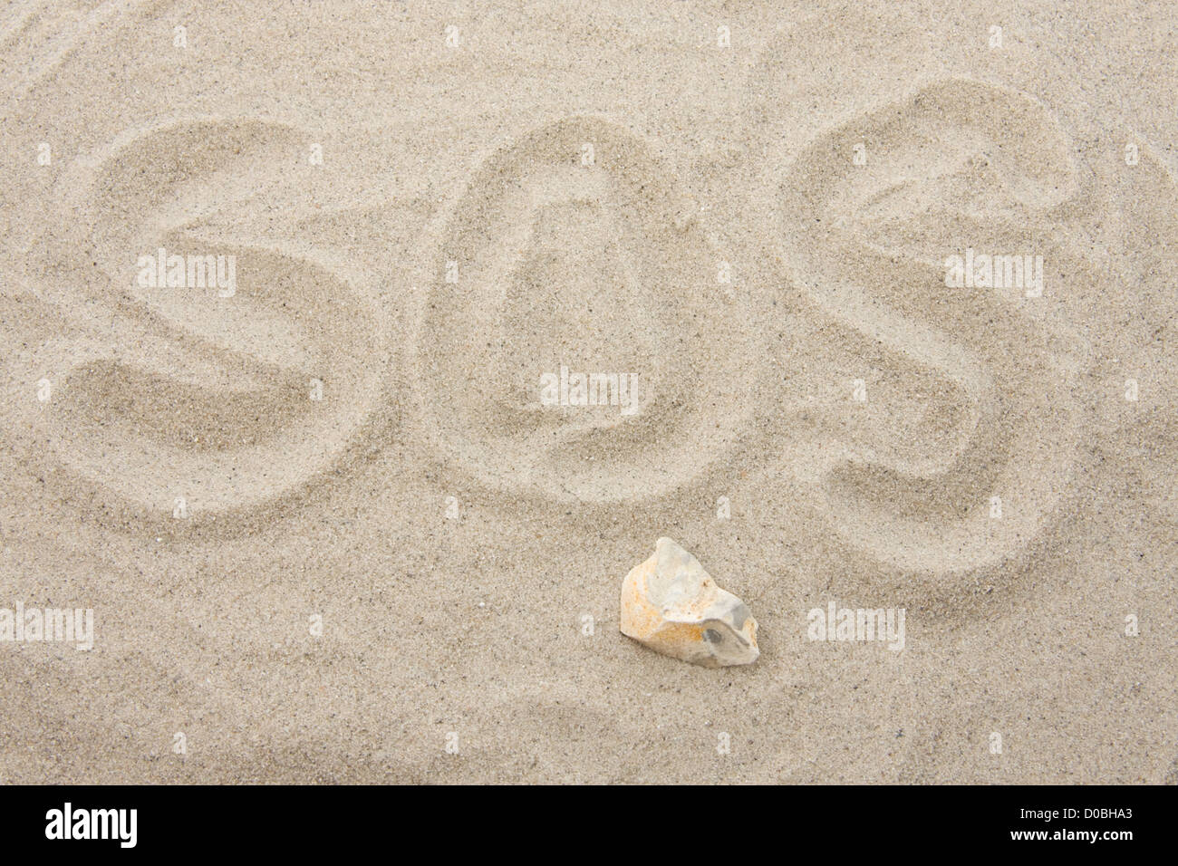 SOS letters written in sand Stock Photo - Alamy