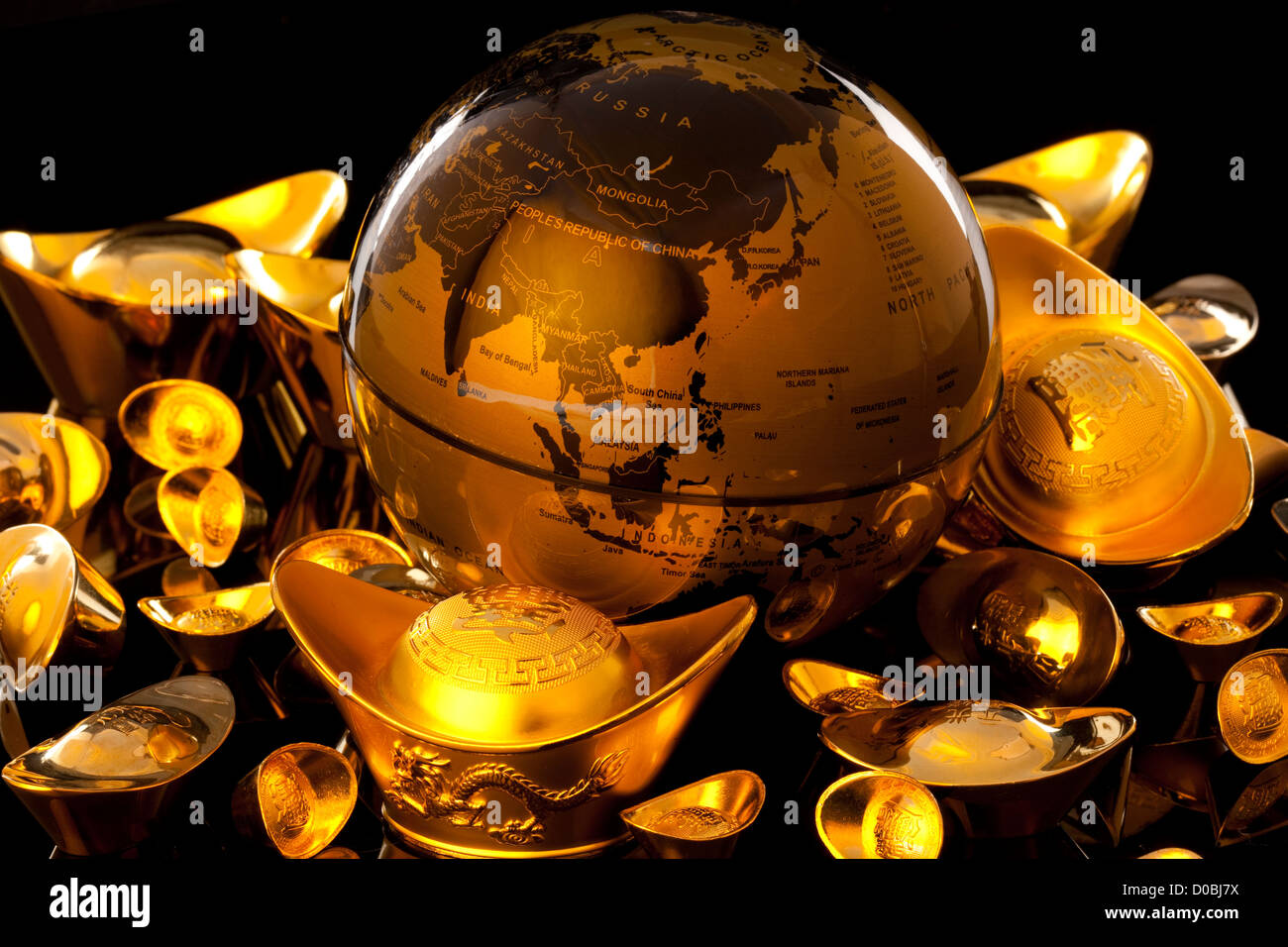 Precious Chinese traditional currency gold yuanbao ingots and globe ...